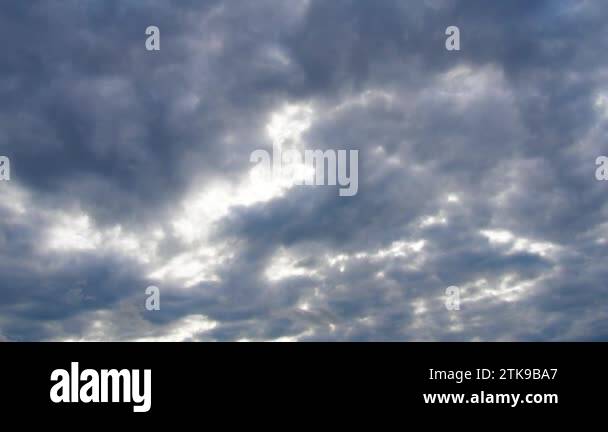 Beautiful blue clouds in the sky. Volumetric light effect. The sunrays are hidden behind the ...