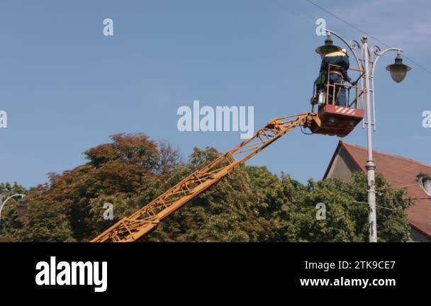 repair works, fix light, crane lifted. Workmen working on repairing ...