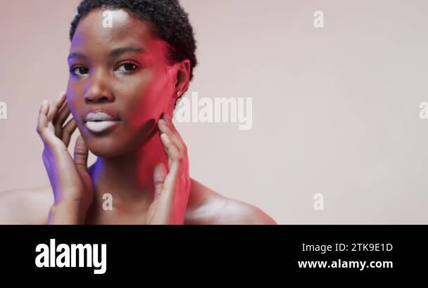African american woman with short dark hair in blue and pink light with ...