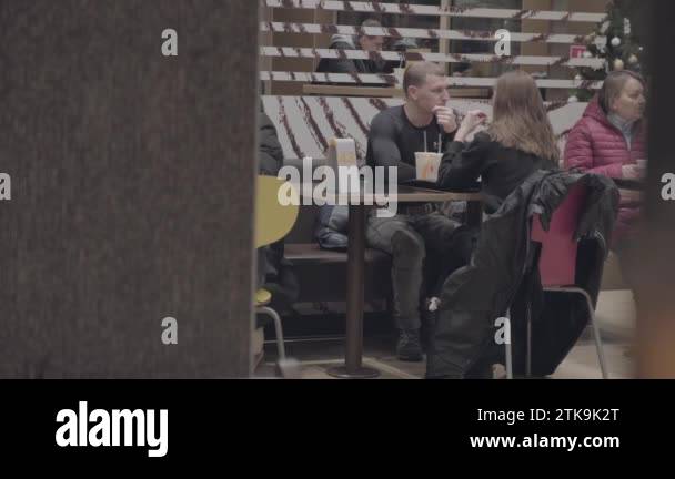 People have lunch at a McDonalds restaurant at a table - a meeting of friends in a cafe. Some ...