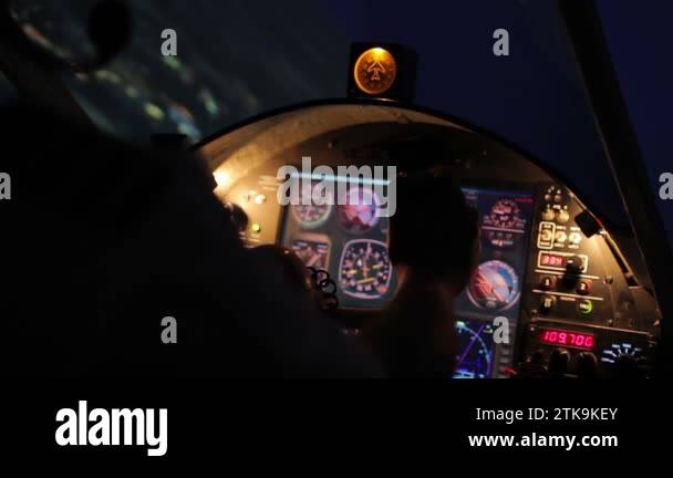 Aircrew commander flying plane above night city, flight panel with ...
