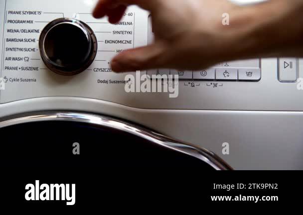 The man in the washing machine, using the knob, sets the washing ...