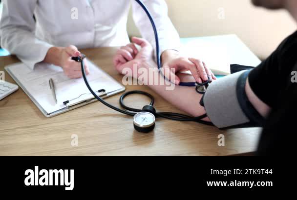 Doctor cardiologist measuring blood pressure with tonometer to patient ...