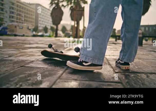 Feet sporty man training skateboarding on street pavement close up ...