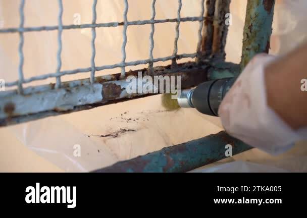 Dirty work process with corroded metal gate surface, workman in gloves ...