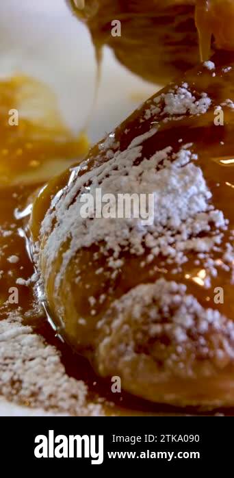 delicious croissant on white plate poured with caramel syrup syrup ...