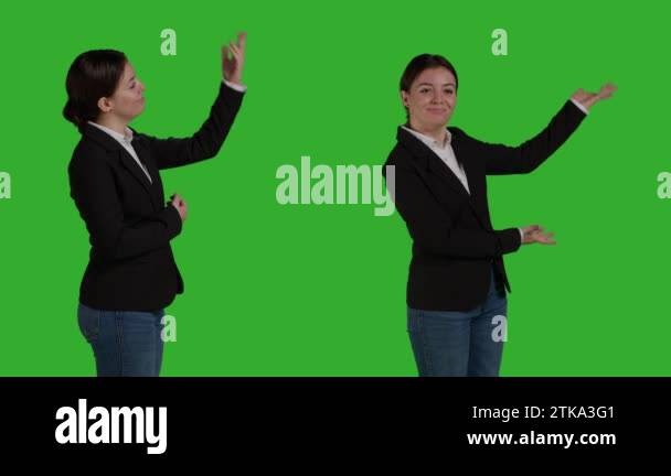 Caucasian businesswoman creating advertisement in studio, pointing sideways to show ad icon or ...