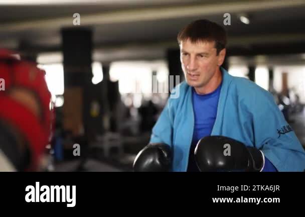 Two martial arts men in kimonos and gloves practicing kicks and punches ...