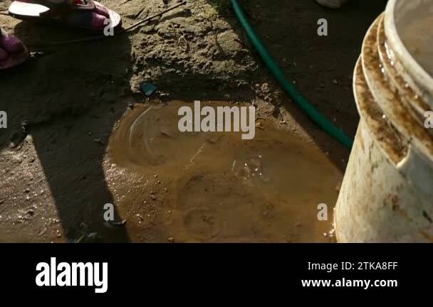 Water dripping from a leaky pipe in farm land. Water flows from a rusty ...