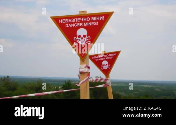 Signs with the warning inscription Danger, mines and fencing tapes in ...