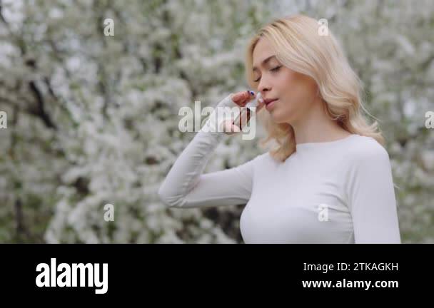 Sick dissatisfied woman spraying nasal medicine during walk in ...