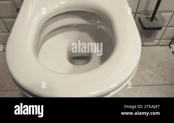 The water is flushed into the toilet. Toilet flush. Close-up on the ...