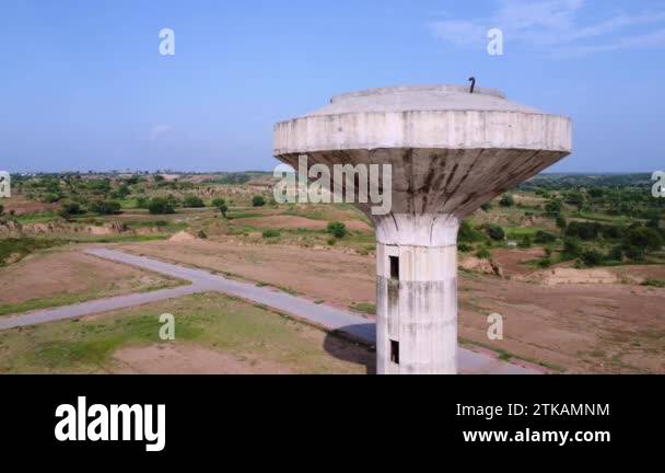 The concrete water tower stands as a silent sentinel of utility and ...