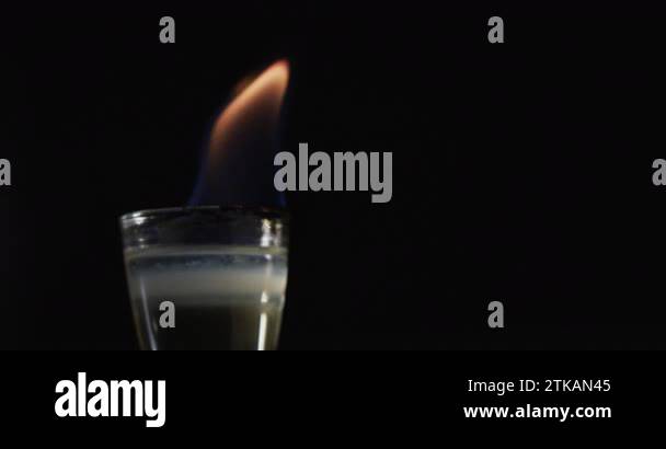 Video of lit alcohol in glass with orange fire flame and copy space on ...