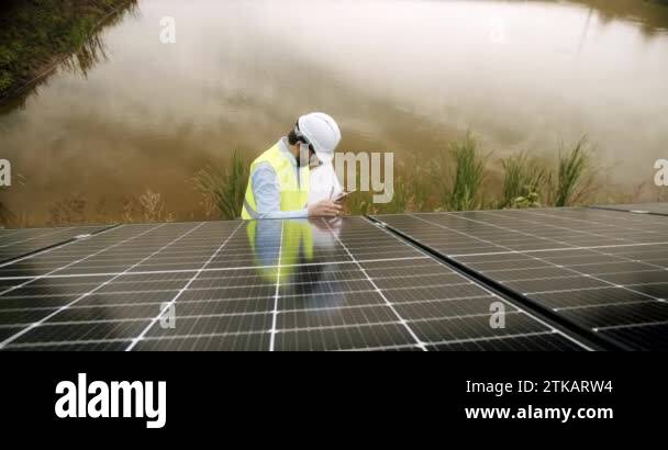 Technician inspect Solar cell Farm through field of solar panels. checking the panels at solar ...