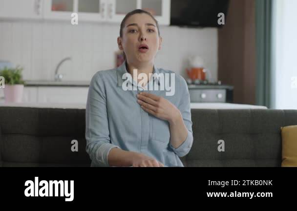 A young woman who is sick is coughing.A young woman in her 30s having difficulty breathing in ...