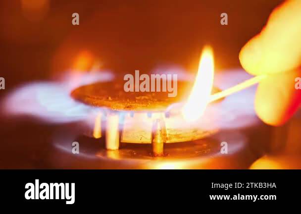 Ignite the gas on the stove with a matchstick, close-up. Manual ...