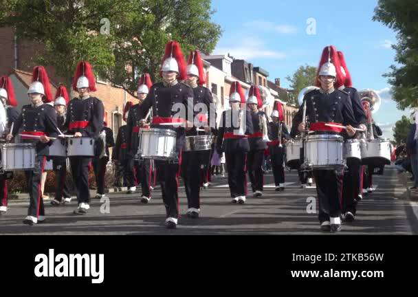 Slow motion low angle video of marching band wearing red helmets and ...