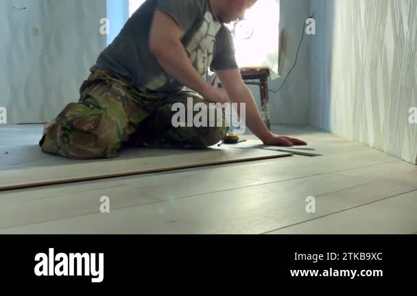 Installation of a laminate board by a professional worker. Floor repair ...
