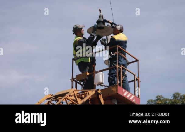 Technician on aerial, fix light, lift bucket. Street light repair work ...
