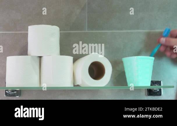 Take a roll of toilet paper in your hand, toilet paper on a glass shelf ...