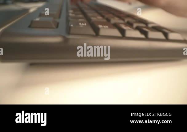 Motion over computer keyboard while woman types at table close first ...