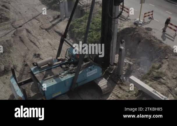 Pile driving machine driving piles into ground site. Modern hydraulic ...