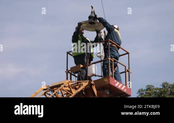 during installation, worker repair, metal pole. Worker is fixing street ...