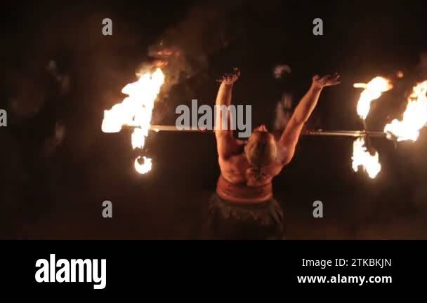 Fire show performance. Handsome male fire juggler performing contact ...