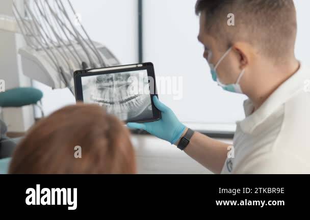 The dentist shows the results of panoramic tomography of the patients ...