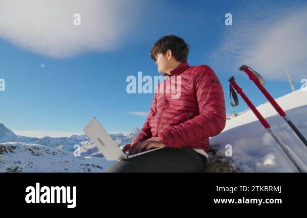 Young asian business man freelance sitting on snow mountain top using ...