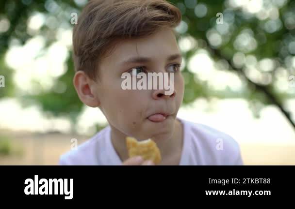 Close-up of a handsome caucasian boy eating nuggets. Man eats unhealthy ...