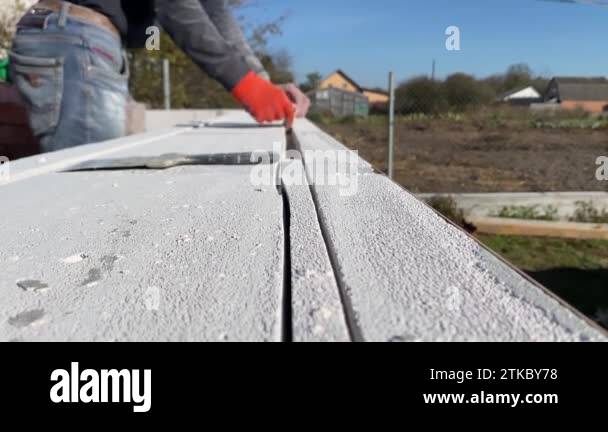 4k video footage of a male builder removing pieces of foam block from a ...