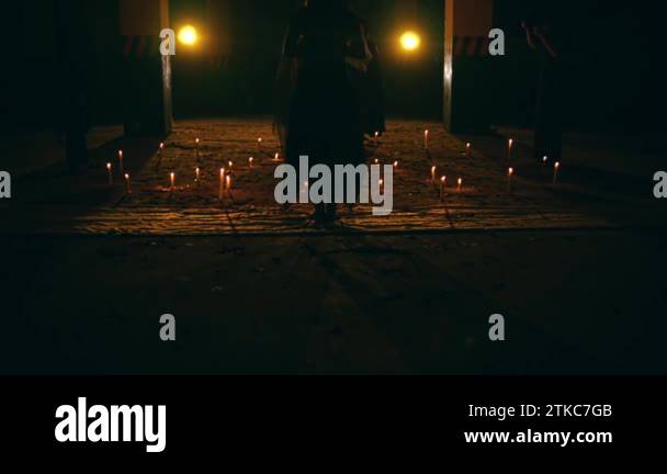 a group of satanic cultists walk amidst an altar of pentagrams and lit ...