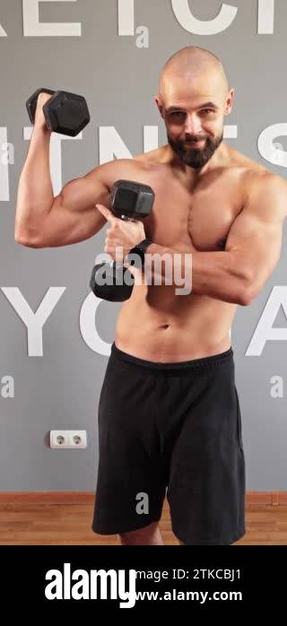 A man with an athletic toned body shows how to perform exercises to ...