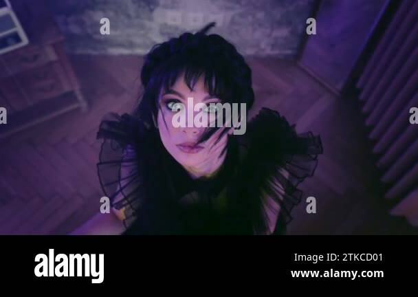 Young woman wearing Wednesday Addams costume style are dancing in a ...