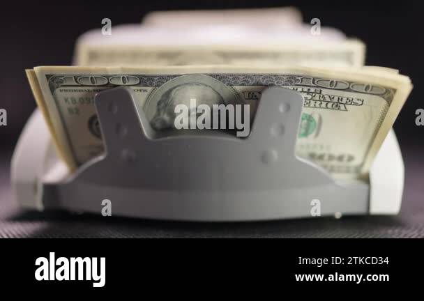 Close-up front view banknote counter with US dollars passing ...