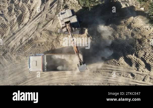 Digger loading trucks with soil view aerial, excavator loading sand ...