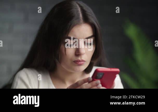 Attractive woman messaging someone. Female smartphone user typing a message. A young girl has ...