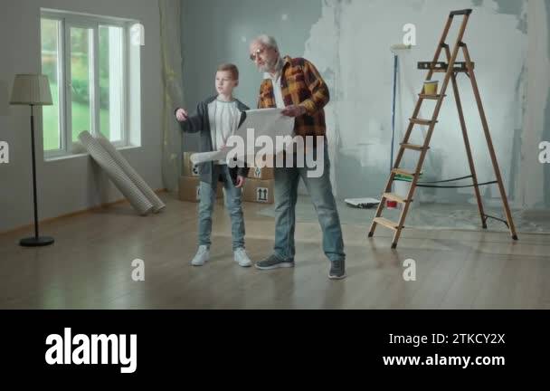 Grandpa and grandson looking through sheet with plan of an apartment ...