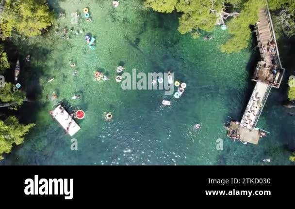 90-degree aerial view people jumping off the deck, swimming, floating ...