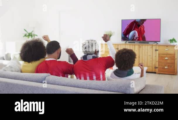 Biracial family watching tv with african american male rugby player ...