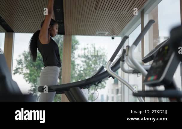 Black digital nomad stretching in a treadmill looking the skyline ...