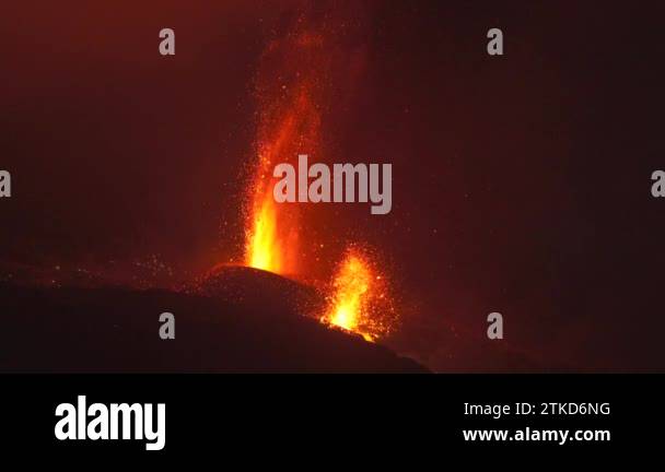 Full shot of a volcano spewing hot lava and magma from the crater with ...