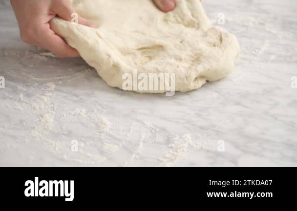 Anonymous woman using rolling pin to stretch fresh dough on table while ...