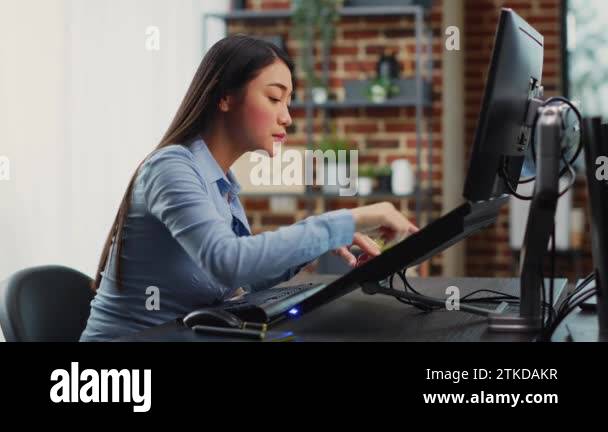 Asian female engineer using touchscreen display to create game ...