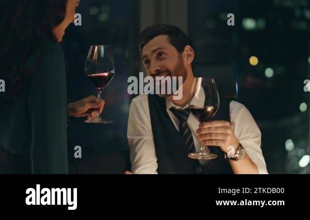 Happy smiling colleagues talking drinking wine in company office late ...