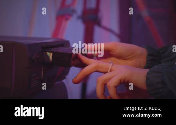 Unrecognizable female hand putting cassette into vintage old school VHS ...