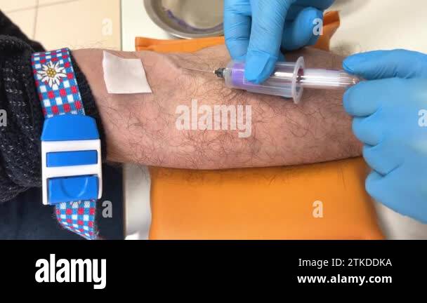 Nurse inserts needle into vein for drip infusion in hospital taking ...