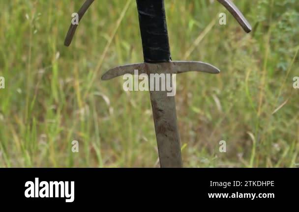 Smooth camera movement, selective focus, a two-handed sword stuck in ...